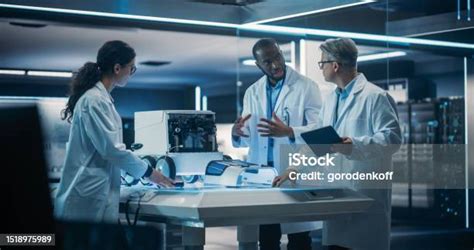 다양한 산업용 로봇 전문가 팀이 모바일 로봇과 함께 테이블 주위에 모였습니다 인공 지능을 사용한 자동화된 로봇 배달 도우미에 대해 논의하는 실험실 가운을 입은 엔지니어 3