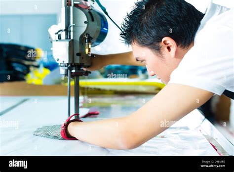 Worker Using A Cutter A Large Machine For Cutting Fabrics In A