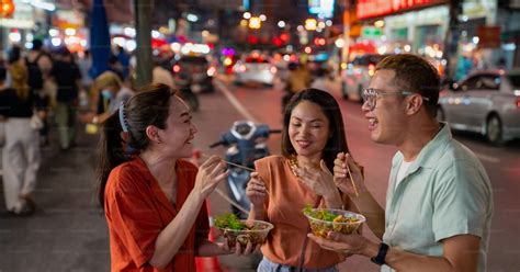 아시아 여성과 Lgbtq 친구들의 4k 그룹은 태국 방콕의 차이나 타운 거리 야시장에서 매운 소스를 곁들인 전통 길거리 음식 바베큐 해산물 구이 오징어를 함께 먹는 것을