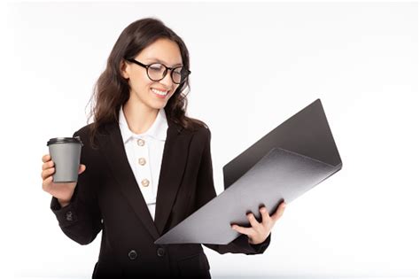 아침에 커피를 마시는 사업가는 상쾌하고 활동적인 아름다운 젊은 일하는 여성이 종이 커피 컵과 폴더를 들고 있습니다 그녀는 안경을