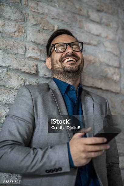 사무실에서 스마트폰을 사용하면서 웃고 있는 성공적인 사업가의 초상화 남자 사업가에 대한 스톡 사진 및 기타 이미지 남자 사업가 웃음 전화 사용 Istock