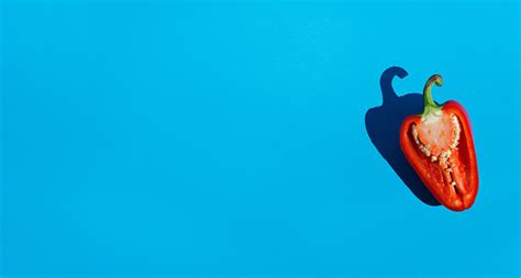 빨간색 슬라이스 피망 매끄러운 패턴과 파란색 배경 플랫 레이에 어두운 검은 깊은 그림자 미니멀한 추상 이미지 건강한 유기농 컨셉 상단 보기 복사 공간 개체 그룹에 대한 스톡