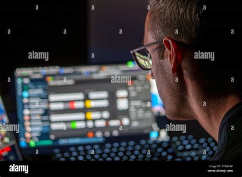 cybersecurity professional analyzing data on multiple screens in a low