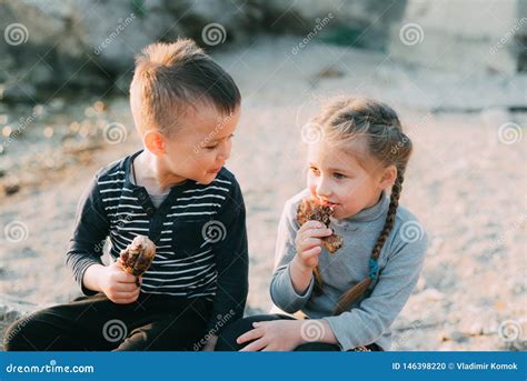 El Hermano Y La Hermana De Ni Os Se Divierten Que Comen El Pollo Shin En La Playa Cerca Del Mar