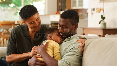 Same Sex Male Couple Bonding At Home With Infant During Daytime Stock Image Image Of Baby