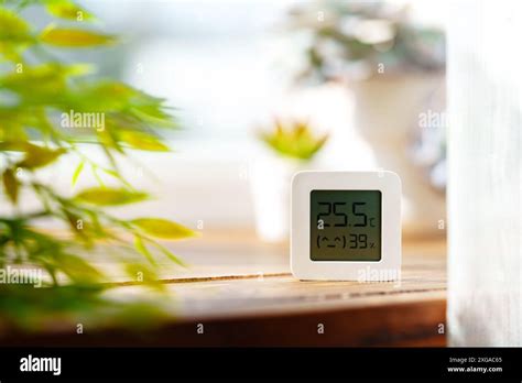 Digital Thermometer Displaying Temperature And Humidity Near Window