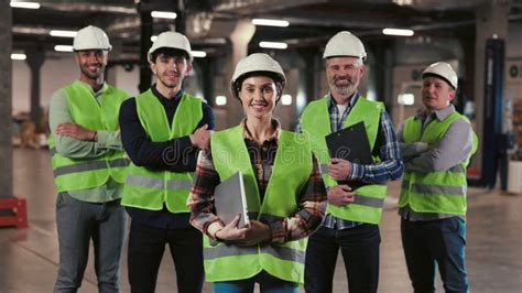varied group of technicians in protective attire guided by a woman