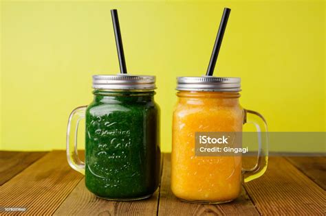빨 대와 함께 녹색과 노란색 해독 스무디와 두 안경 나무 테이블과 노란색 Backgraund에 시금치와 호박 스무디 0명에 대한 스톡 사진 및 기타 이미지 Istock