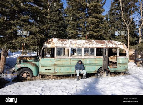 Woman Sitting In Front Of The Into The Wild Movie Prop In Alaska Stock