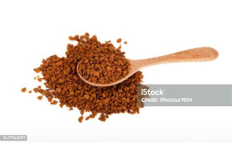 나무 숟가락에 인스턴트 커피와 흰색 배경에 고립 된 땅에 흩어져 있습니다 인스턴트 커피는 사람들이 뜨거운 커피를 빠르게 준비 할 수있게 해주는 양조 커피 원두에서 추출한