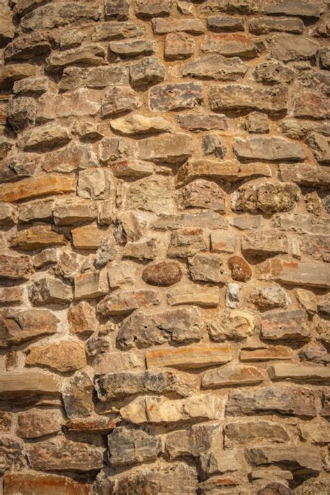 집 밖의 거친 건물 건설 건축 고대의 구조 기초 껄끄 러운 낡은 단단한 돌 디자인 디테일 따뜻한 러스틱 바위 바위투성이의 배경 벽 벽돌