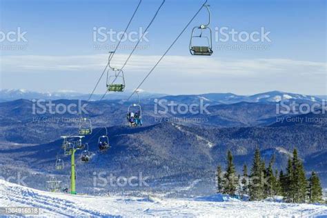 러시아 셰레게시 스키 리조트의 전나무로 덮인 산봉우리 배경에 대한 의자 스키 리프트 알타이 산맥의 겨울 스포츠 레저 아름다운 자연 경관 Sheregesh에 대한 스톡 사진