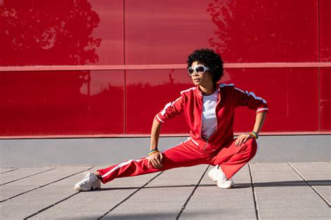 화창한 날에 빨간 색벽에 짧은 머리와 스포츠웨어를 가진 젊은 아프리카 계 미국인 여성 길거리 스타일에 대한 스톡 사진 및 기타 이미지 길거리 스타일 빨강 20 24세