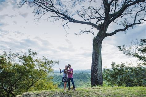 Free Photo Couple In Front Of A Tree On A Hill