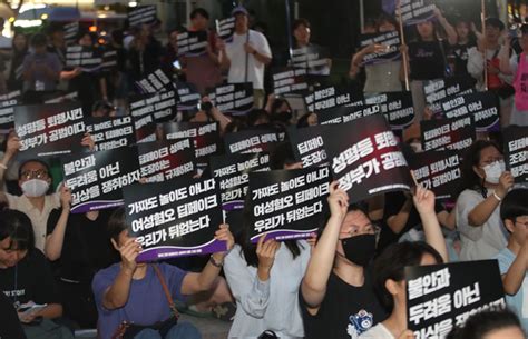 participants hold up signs during a rally against deepfake pornography