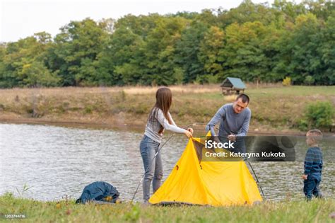 작은 아들과 함께 행복한 가족이 캠핑 텐트를 설치했습니다 행복한 어린 시절 부모와 함께 캠핑 여행 어린이가 텐트 를 설정하는 데 도움이됩니다 2명에 대한 스톡 사진 및 기타