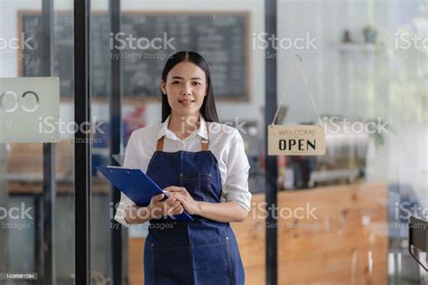 젊은 아시아 여성 직원이 음식과 음료 개념을 여는 표지판을 들고 가게 앞에 서 있습니다 Fashion Show에 대한 스톡 사진 및 기타 이미지 Fashion Show