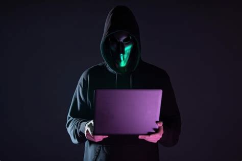 Un Hacker Con Una Capucha Que Usa Una Computadora Portátil Aislada En Un Fondo Oscuro Con Luz De