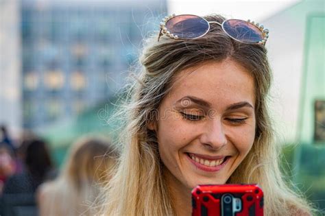 Jovencita Hermosa Sonriendo Mientras Mandaba Mensajes De Texto En Su Smartphone Imagen De