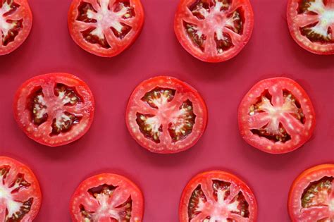 얇은 피부 밝은 빨간색 살과 씨앗 건강한 식생활 포스터 벽지 배경 디자인 높은 보기 표시 빨간색 배경에 퍼진 토마토 조각의 전체 프레임 이미지 0명에 대한 스톡 사진 및