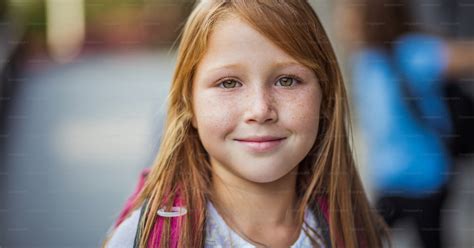 빨간 머리를 가진 쾌활한 소녀의 초상화는 카메라를 향해 웃고 있다 초점은 전경에 있습니다 사진 Unsplash의 공생 이미지