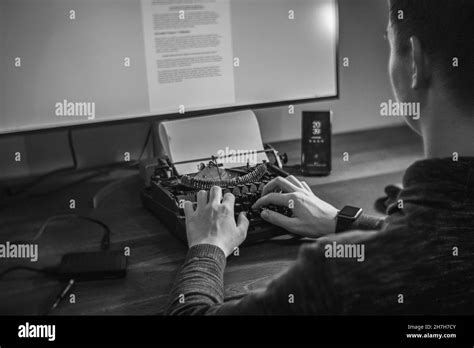 Grayscale Shot Of A Caucasian Man Typing On A Typewriter Stock Photo Alamy