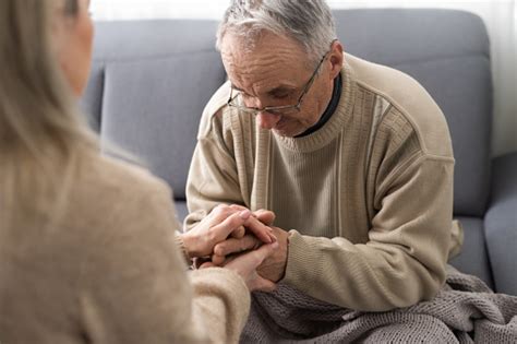 돌보는 젊은 물리 치료사와 함께 재활 절차에 참여한 노인 연금 수급자의 머리 사진 보행 장애를 가진 은퇴한 남자는 전문적인 도움에 감사함을 느낀다 2명에 대한 스톡 사진 및