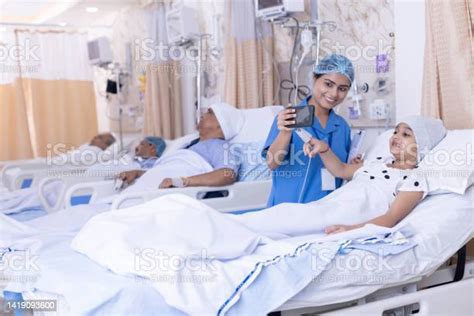 병원 병동에서 침대에 누워있는 어린 소녀 환자를 위로하는 젊은 간호사 암에 대한 스톡 사진 및 기타 이미지 암 아이 암세포 Istock
