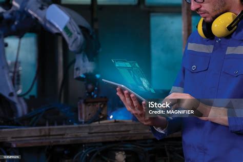 엔지니어 점검 및 제어 자동화 로봇 암 지능형 공장 산업용 로봇 암기계가 시스템 소프트웨어를 모니터링합니다 용접 로봇 및 디지털 제조 작업 25 29세에 대한 스톡 사진 및