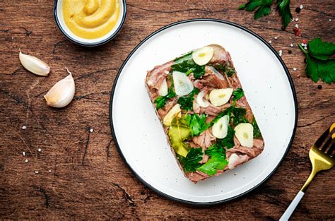 겨울 아스픽 고기 마늘과 디종 머스타드 드레싱을 곁들인 접시에 매운 젤리 국물에 차갑게 삶은 쇠고기 오래 된 소박한 테이블 배경 평면도 육즙 젤리에 대한 스톡 사진 및 기타