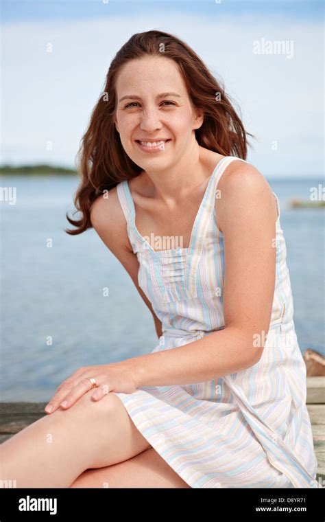 Woman Sitting On Jetty Smiling Portrait Stock Photo Alamy
