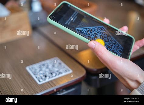 Closeup Of Guest Hand Ordering Meal In Restaurant While Scanning Qr Code With Mobile Phone For