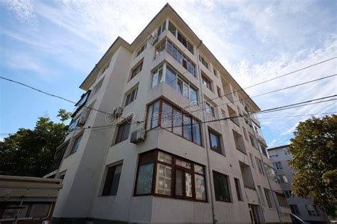 Modern Residential Architecture Showcasing Large Windows And A Flat Roof Under A Clear Blue Sky