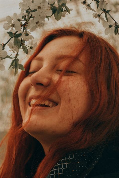 Вінтажне фото руда дівчина посміхається в місті біля квітучих дерев весняні жіночі фото