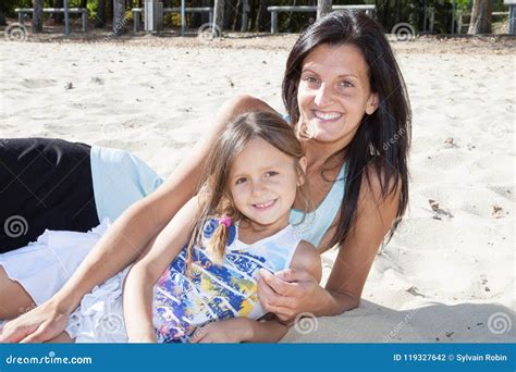 Mother And Daughter Lying Together On The Beach With Fully Happiness