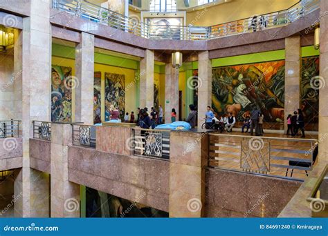 Visitors Admiring The Murals At The Palacio De Bellas Artes In Mexico