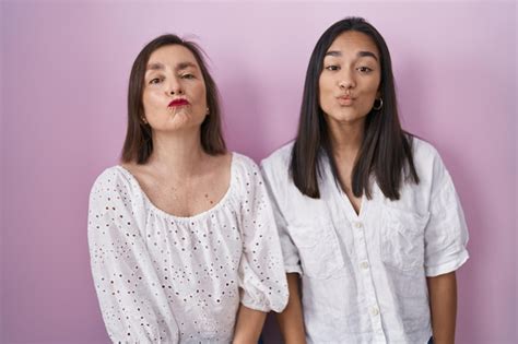 Hispanische Mutter Und Tochter Schauen Zusammen In Die Kamera Und Blasen Einen Kuss Auf Die Luft