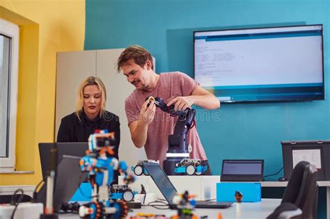 A Group Of Colleagues Working Together In A Robotics Laboratory Focusing On The Intricate