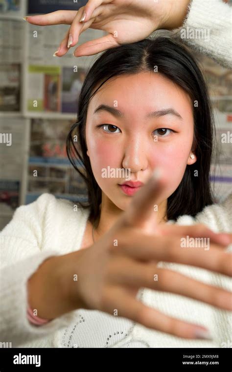Close Up Portrait Of Beautiful Teenage Asian Girl With Hands Framing