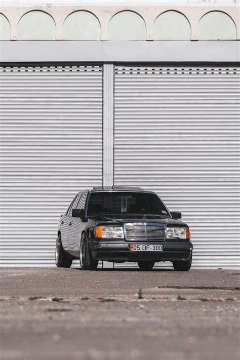 W124 가을 거리 검은 차 고급 세단 고급 승용차 고전적인 디자인 교통 낮 도시 배경 도시의 독일 차 레트로 레트로 자동차 메르세데스 벤츠