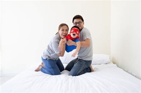 Père Mère Et Fils Asiatiques Jouent Au Super Héros Sur Le Lit Dans La