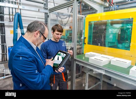 Manager And Worker Doing Quality Assessment In Plastics Factory Stock