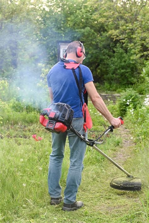 Worker Mowing Tall Grass With Electric Or Petrol Lawn Trimmer In The Backyard It Doesn T Work