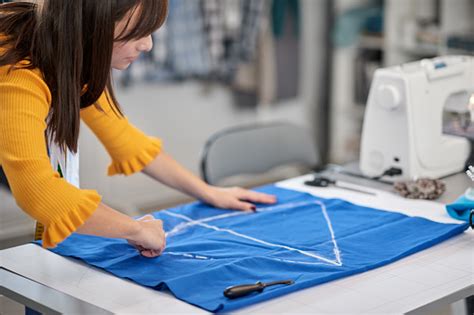 그녀의 스튜디오에 서서 아름다운 이브닝 드레스를 위해 파란색 직물에 그림 계획에 서 창조적 인 백인 패션 디자이너 갈색 머리에 대한 스톡 사진 및 기타 이미지 Istock