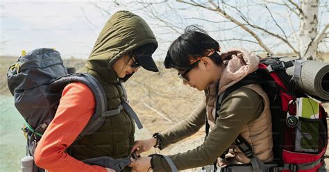 가장 친한 친구 또는 자매와 함께 하이킹하는 젊은 아시아 여성의 측면 모습은 그녀가 무거운 여행 배낭을 조정하고 고치는 것을 돕습니다 사진 Unsplash의 러시아 이미지