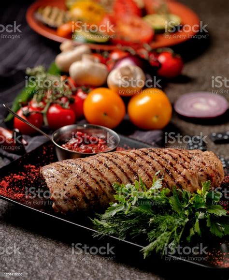 최고의 전망 맛있는 스테이크 돼지 허리 로스트 레드 바베큐 소스 검은 돌 배경에 야채와 향신료와 채소를 요리 구운 고기 맛있는 바베큐 케첩 소박한 스타일 건강한 생활방식에