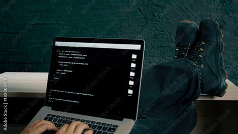 Hacker Feet Up To Table Hacker With Laptop Coding Exploit To Crack