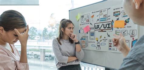 Group Of Asian Ux Developer And Ui Designer Serious Brainstorming About Mobile App Interface On