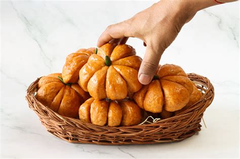 고리버들 바구니에 담긴 수제 할로윈 빵 빵 더미 살구 잼 글레이즈드 음식 더미 흰색 대리석 효과 배경에서 갓 구운 수제 할로윈 빵 줄기로 호박 디자인 롤을 선택하는 알아볼