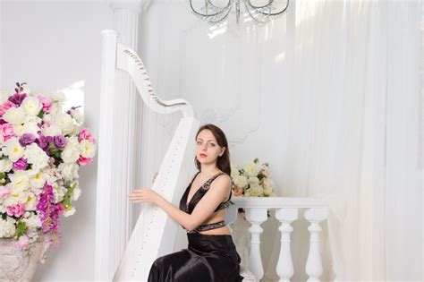 Premium Photo Pretty Elegant Young Woman Playing The Harp In A